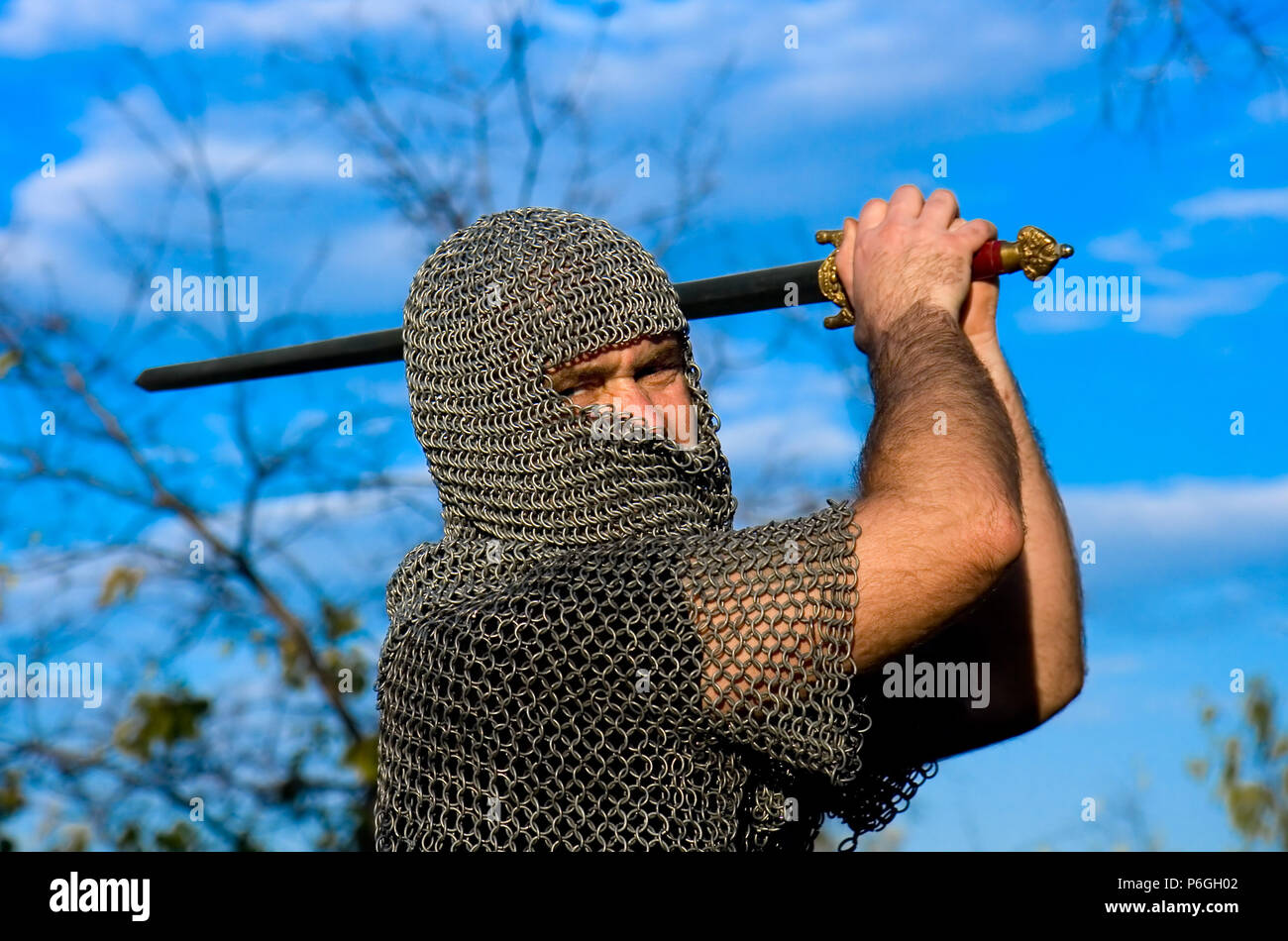 Knight wearing armour and hold on a sword Stock Photo - Alamy