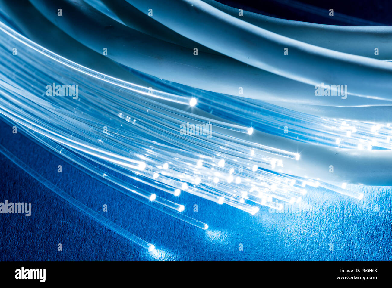 Network cables and optical fibers with light on blue background Stock ...