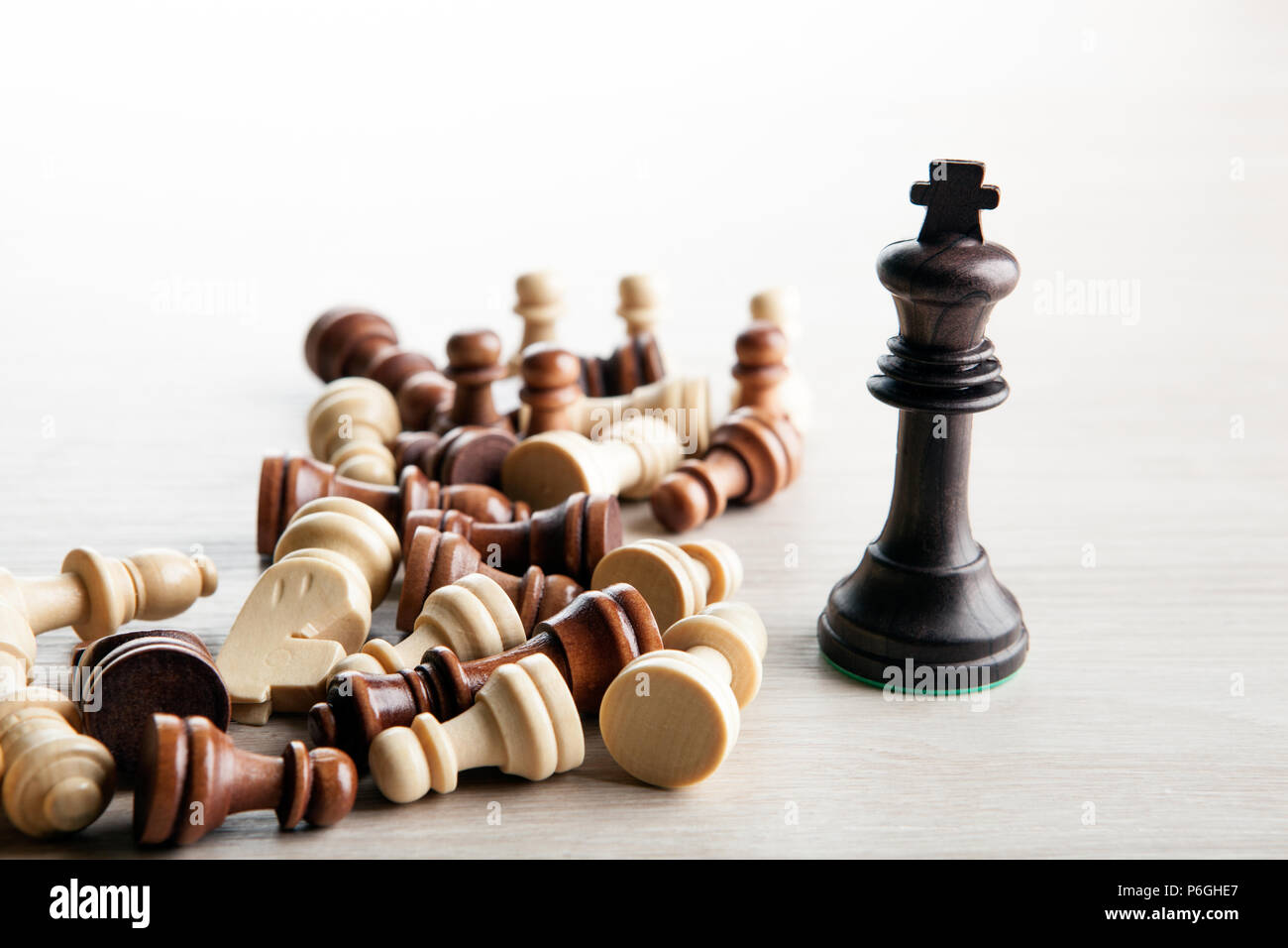 scattered chess pieces and chess piece of the black king on a grey ...