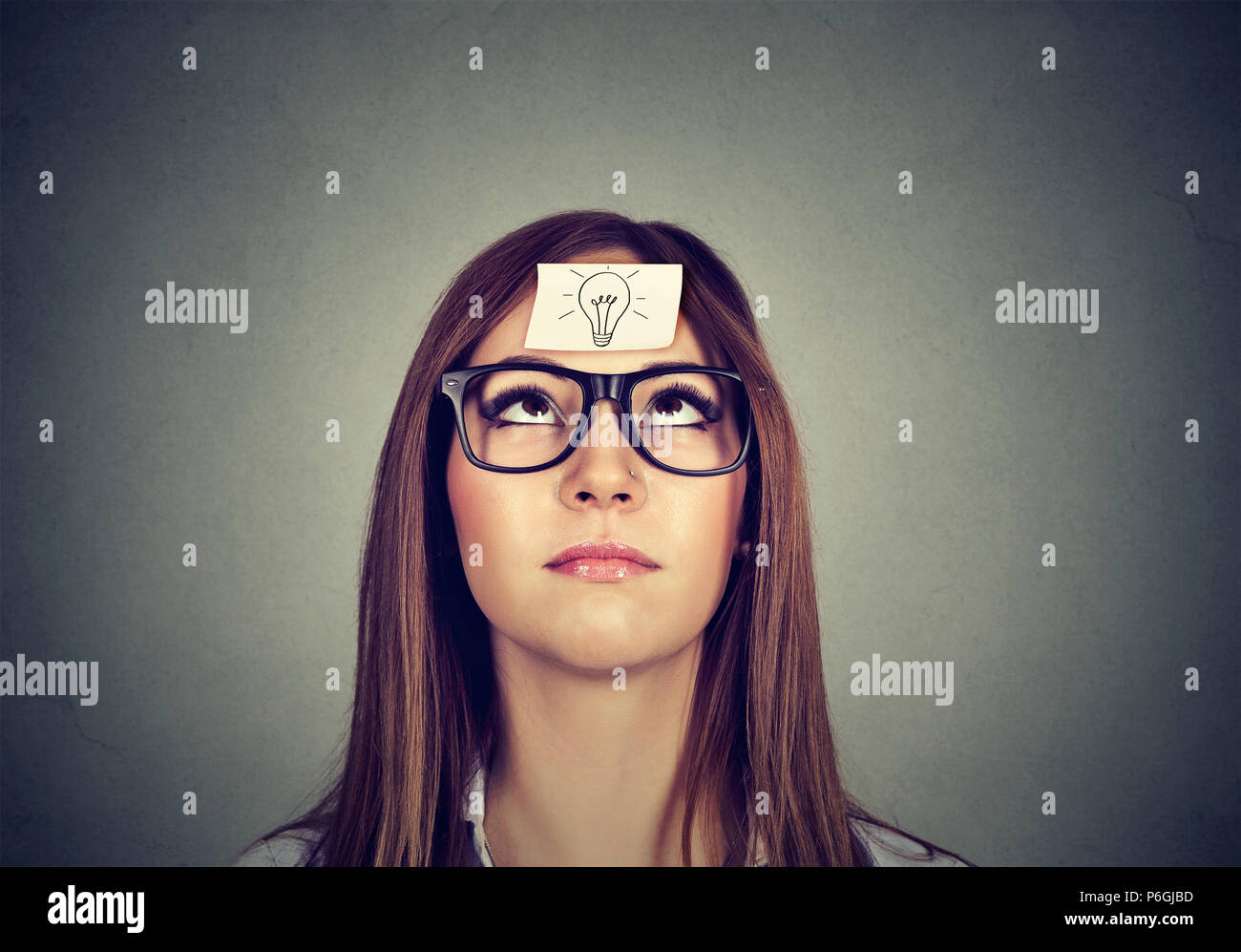 Young woman having sticker on face with symbol of light bulb and ...