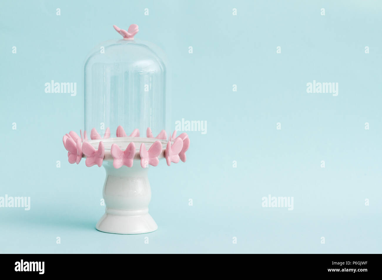 Empty bell jar with pink butterfly design on blue background Stock ...