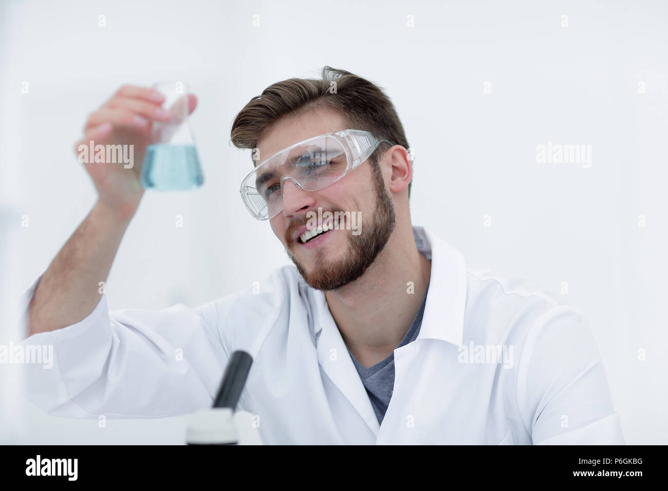 closeup. chemist holding a beaker with a solution Stock Photo - Alamy