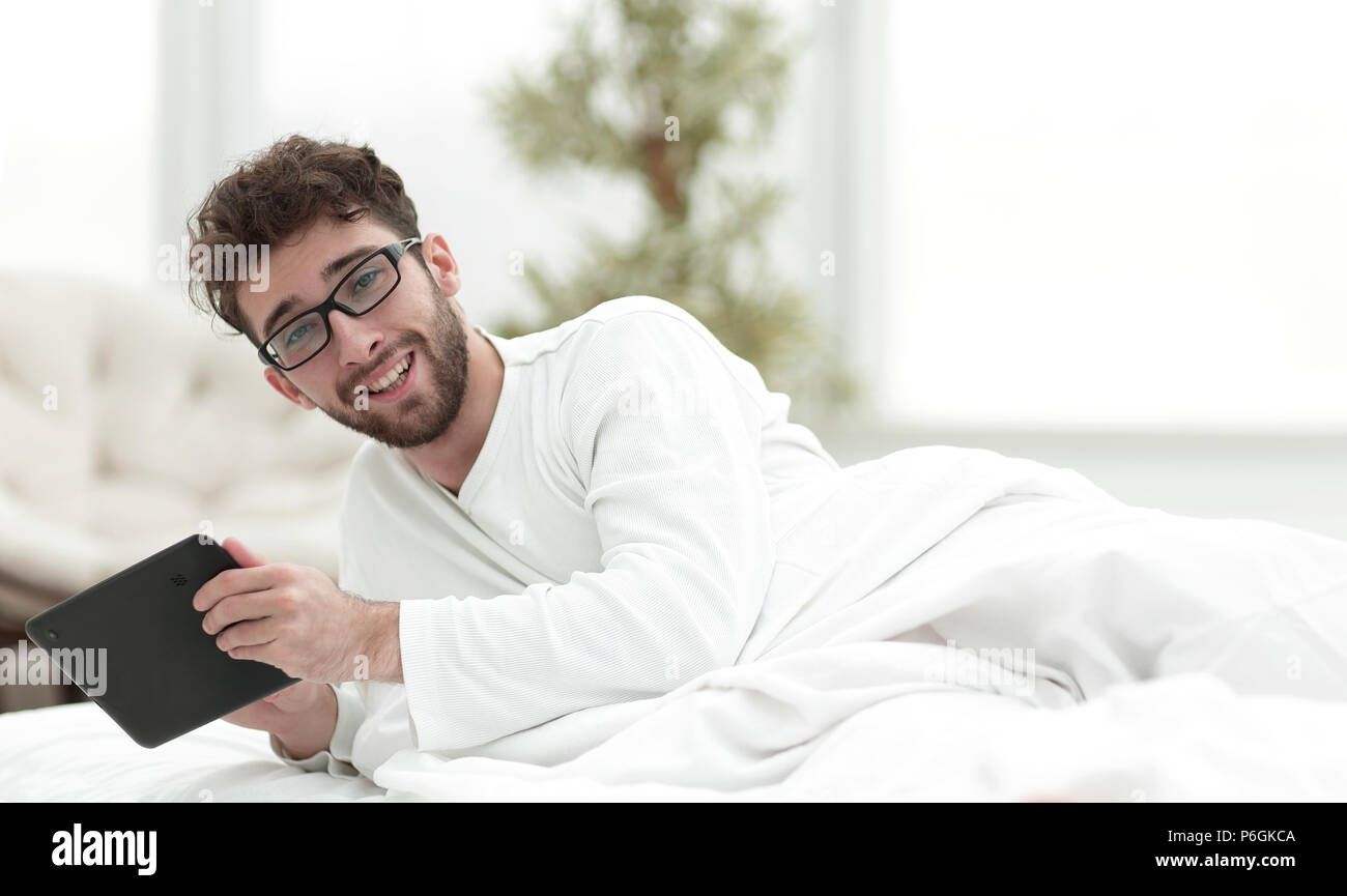 closeup.sleepy man taking digital tablet Stock Photo - Alamy