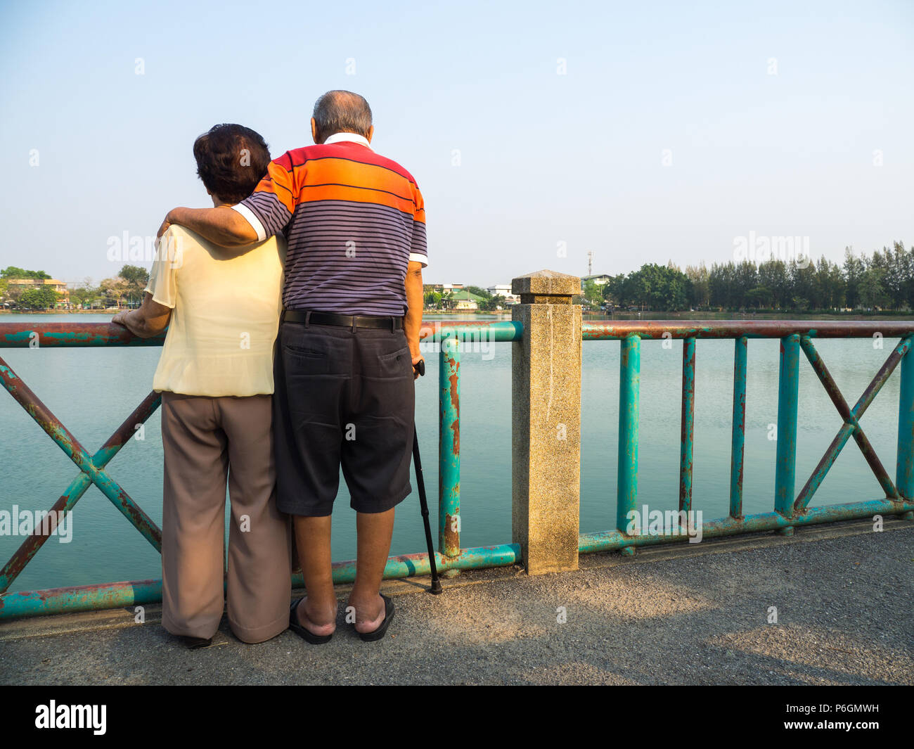 Happy romantic senior asian couple stand on the bridge in front of the ...