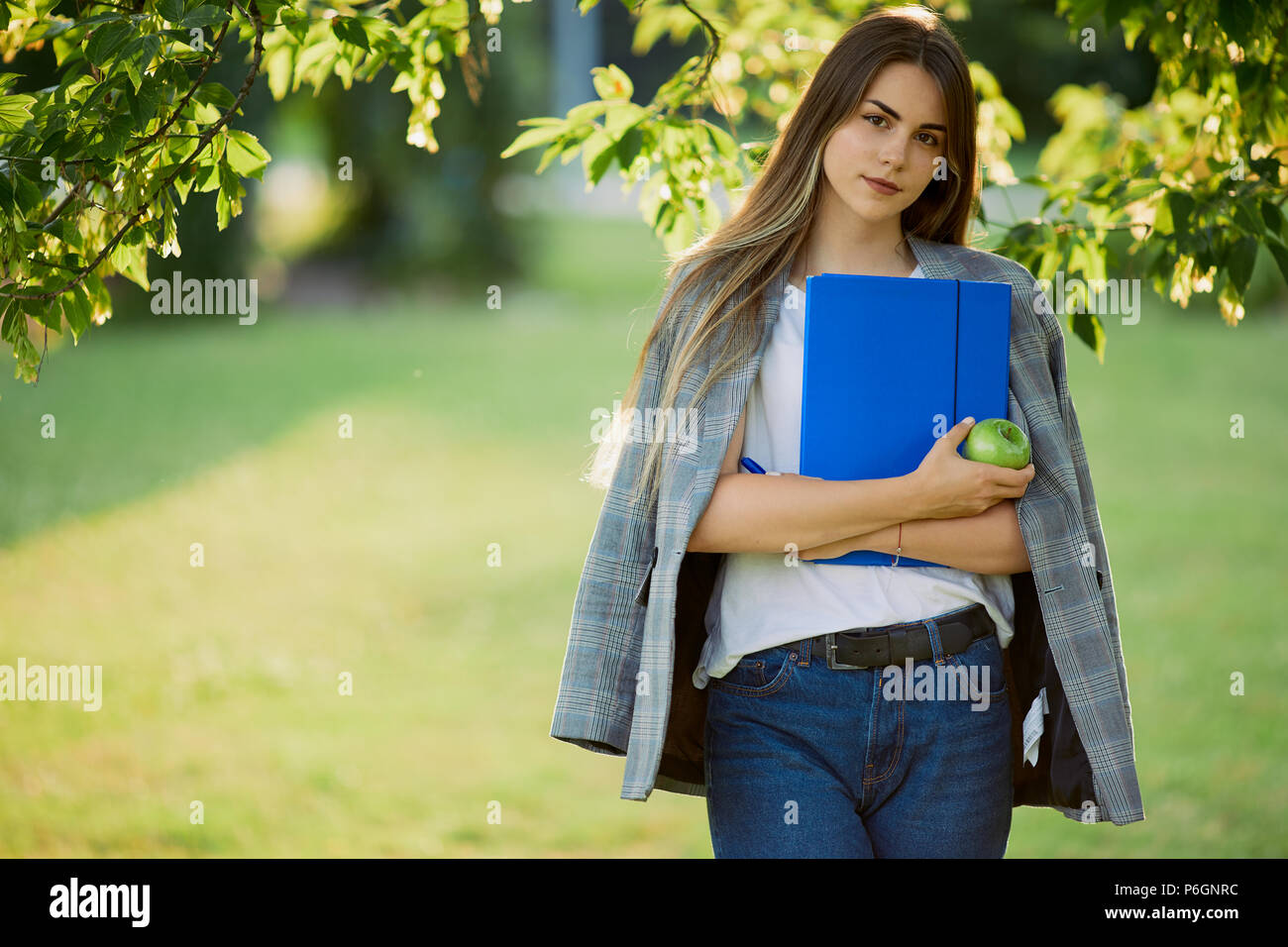 Pretty girl with her book in park background, sunset Stock Photo - Alamy