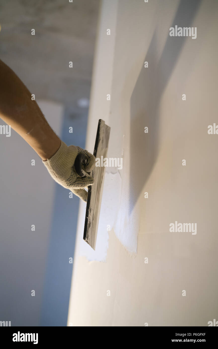 worker applying putty on the wall with putty knife, shallow focus Stock ...