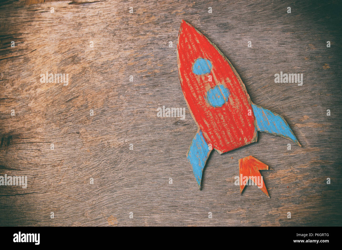 Top view image of rocket cut from paper and painted over wooden grunge ...