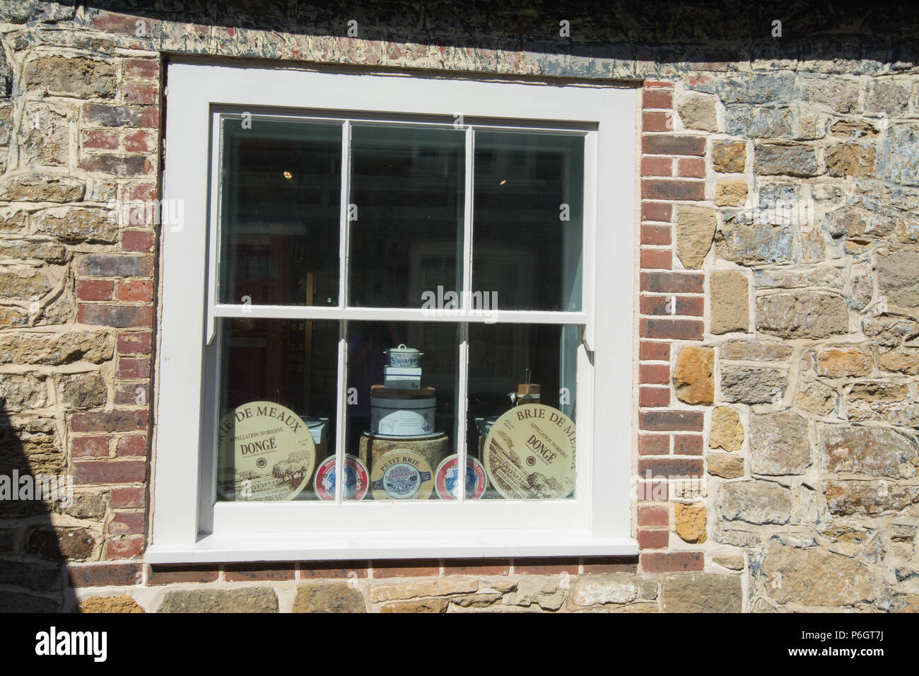Window display of cheeses for sale in Petworth, West Sussex, UK Stock ...