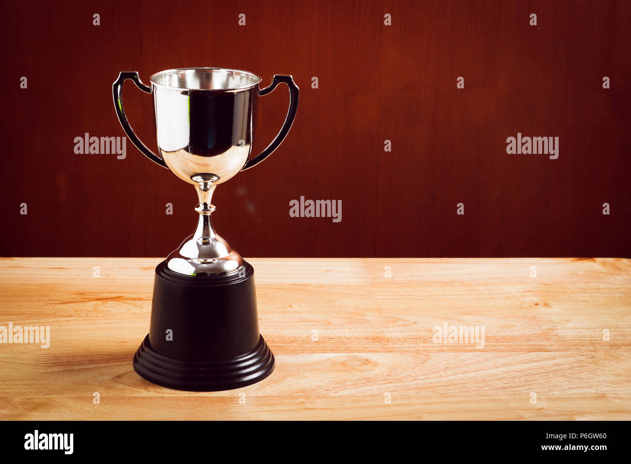 winner concept silver trophy placed on wooden table with background ...