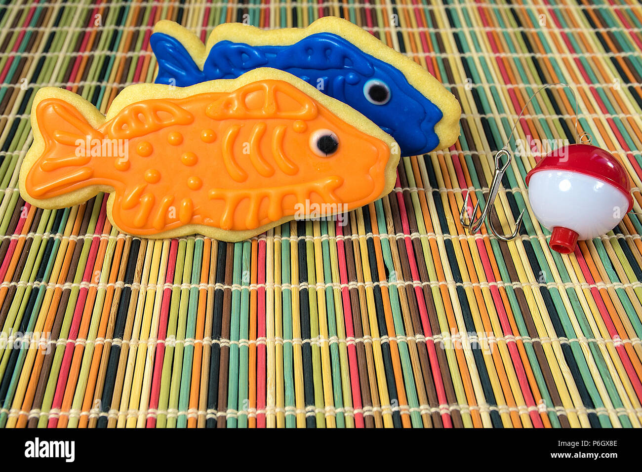 blue and orange icing on fish cookies with fishhook on fishing bobber ...
