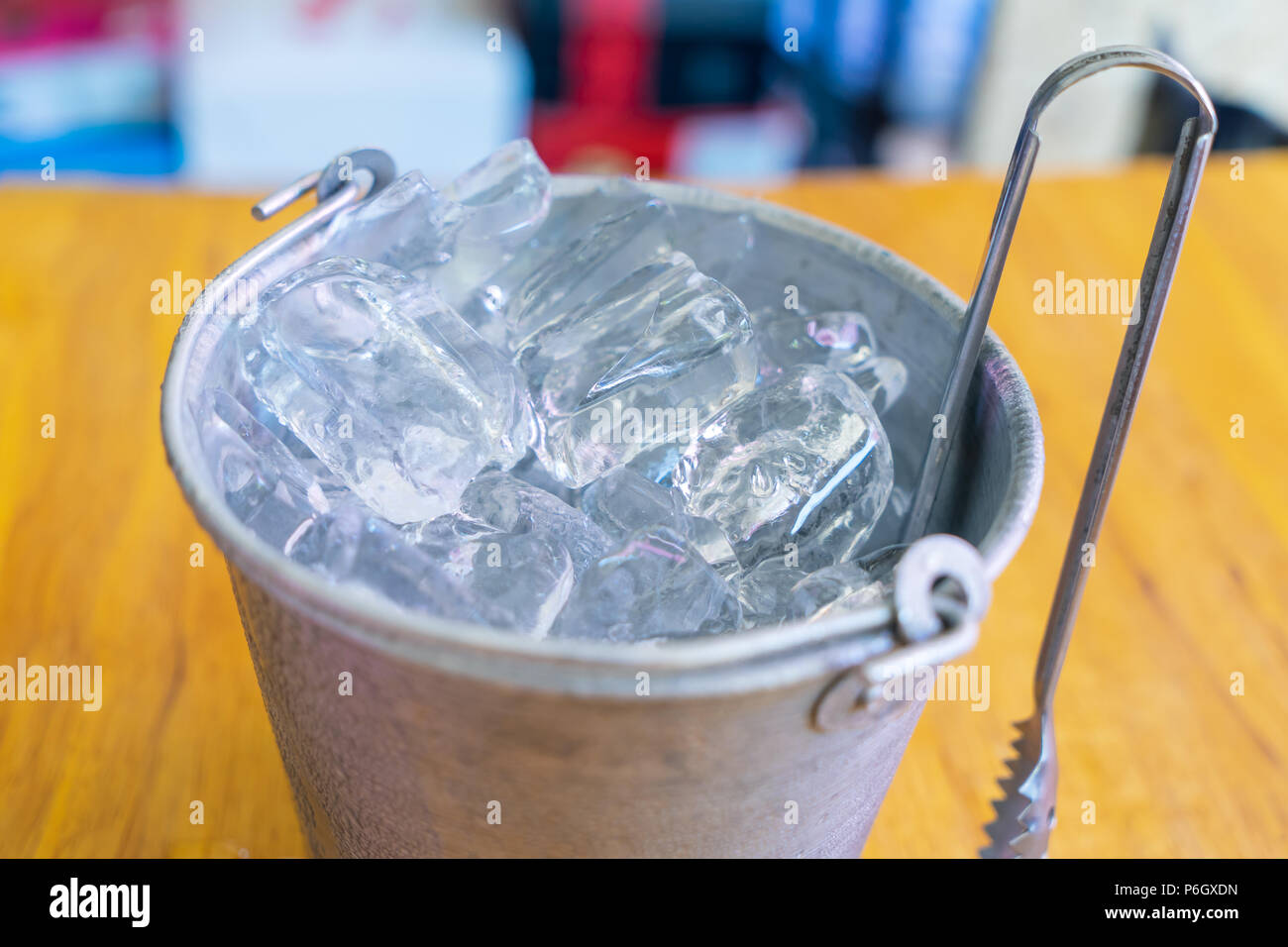 The silver bucket of ice cube on the wooden table background with water ...