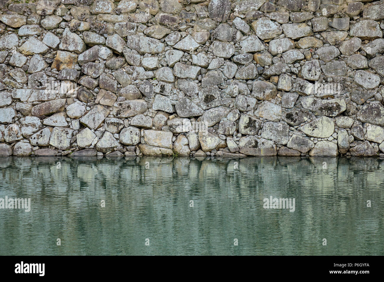 Stone wall of ancient castle with the moat in Himeji, Japan Stock Photo ...