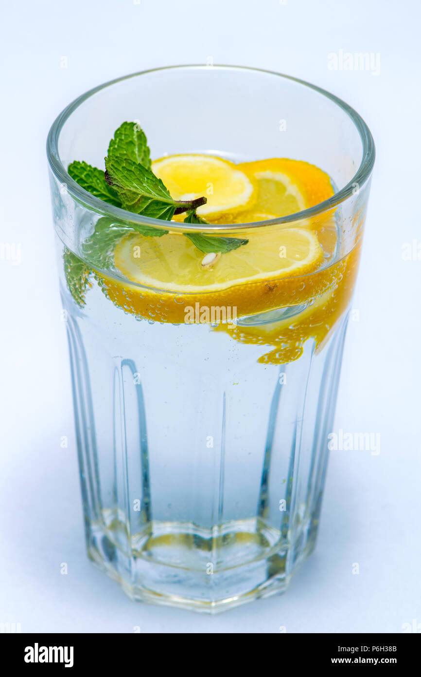 Glass Water with mint and yellow citron half isolated with a white ...