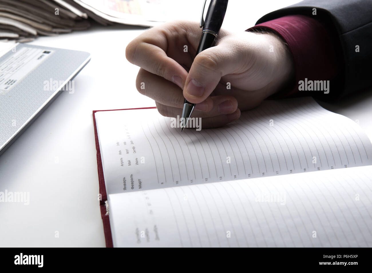 diary and human hand holding a pen close-up Stock Photo - Alamy