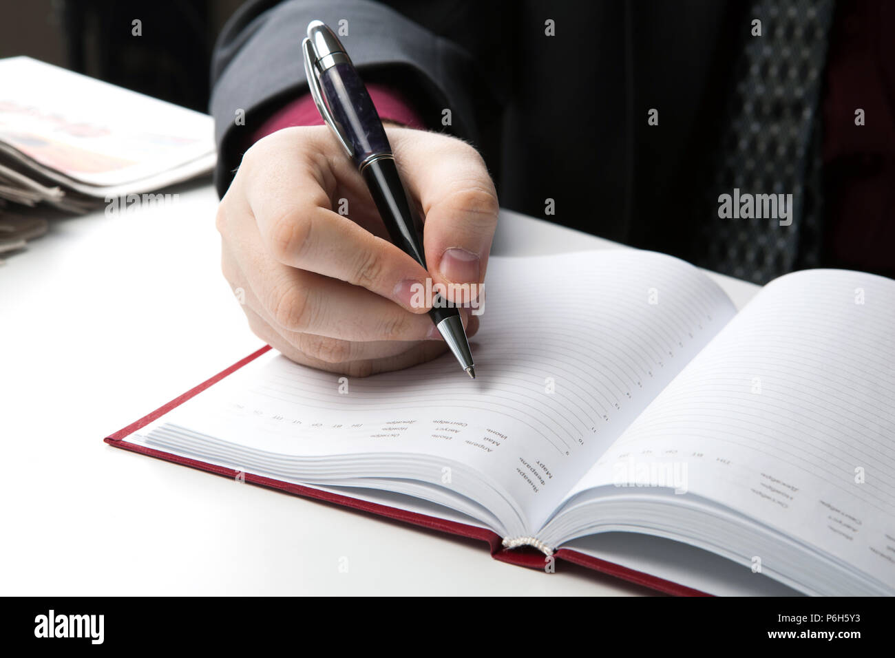 diary and human hand holding a pen close-up Stock Photo - Alamy