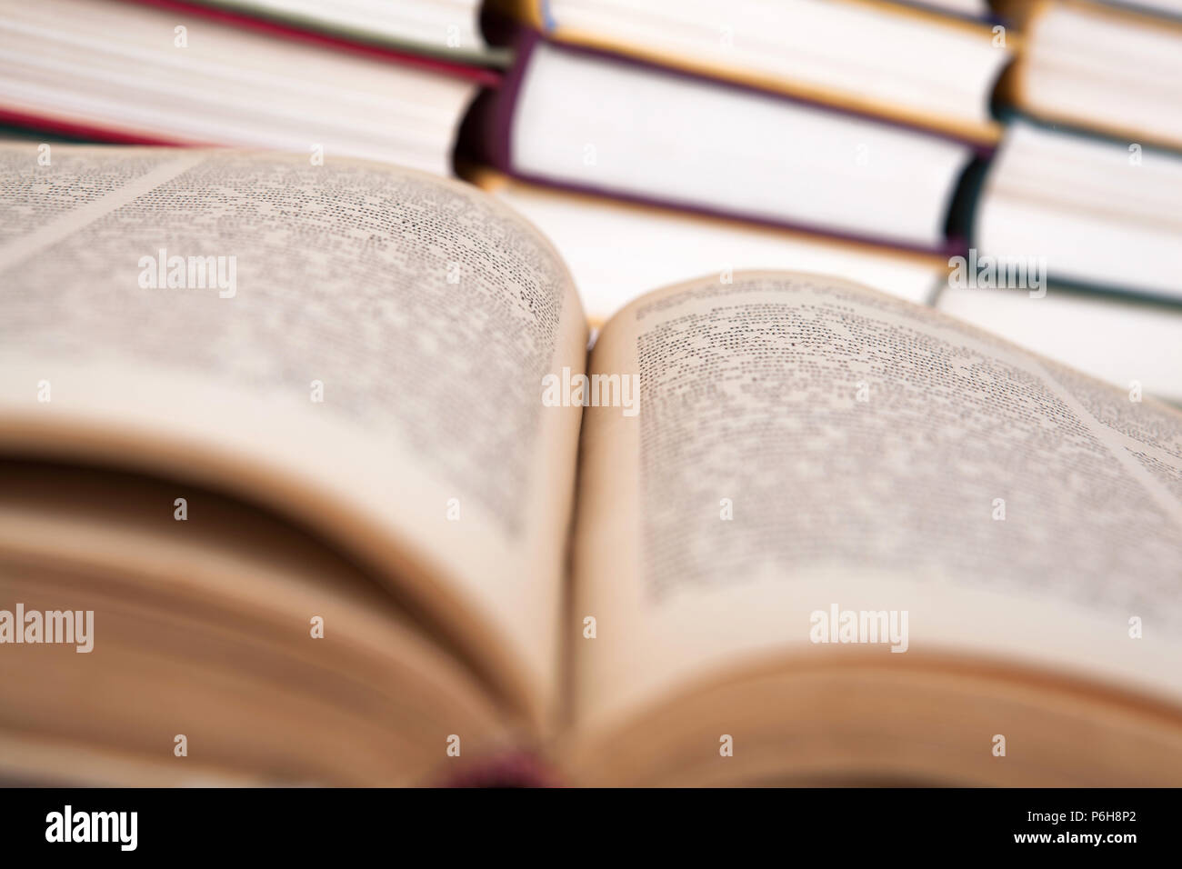 open book on with pile of books close up Stock Photo - Alamy
