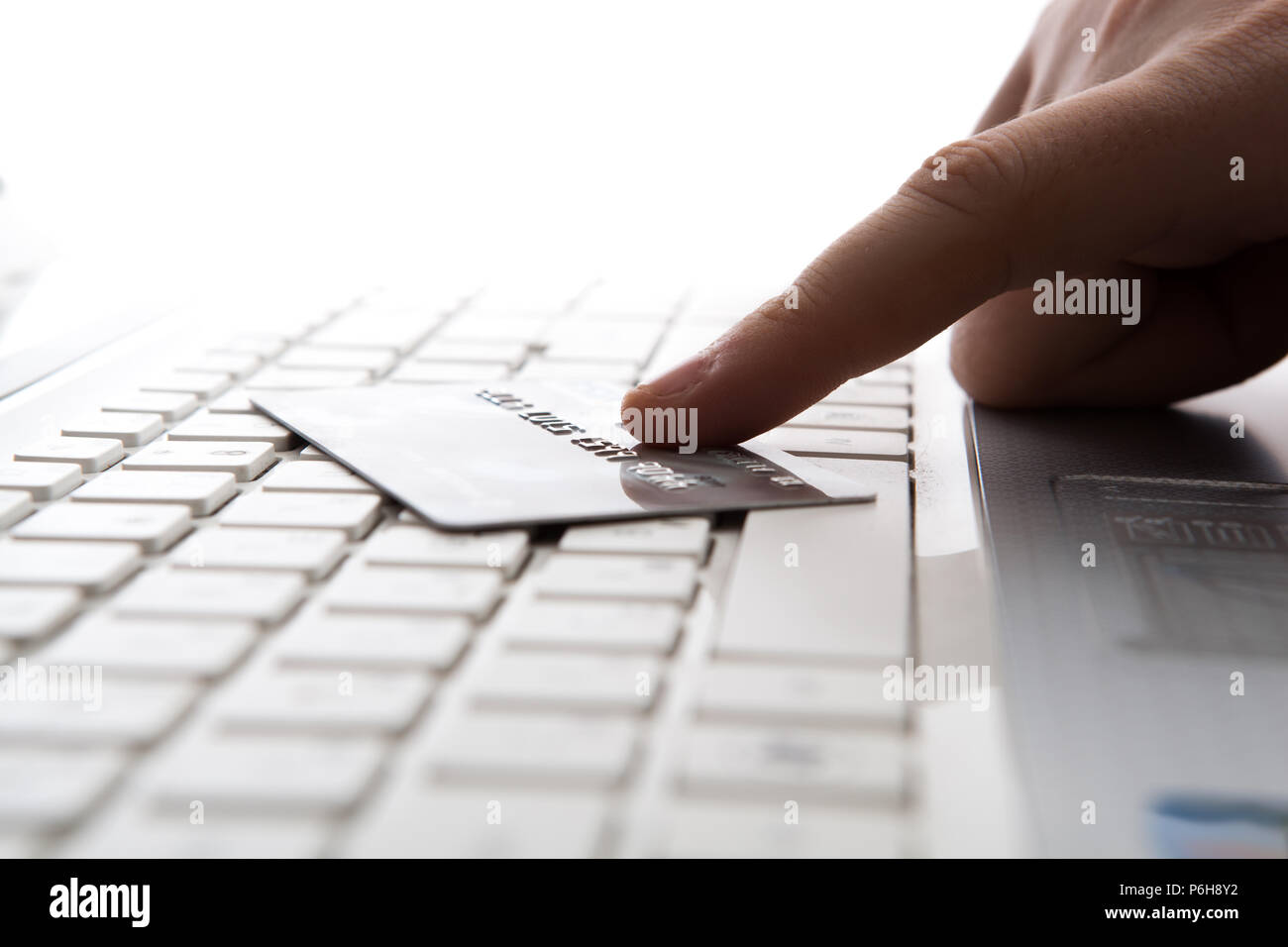 human hand holding a bank card on the keyboard on a white Stock Photo ...