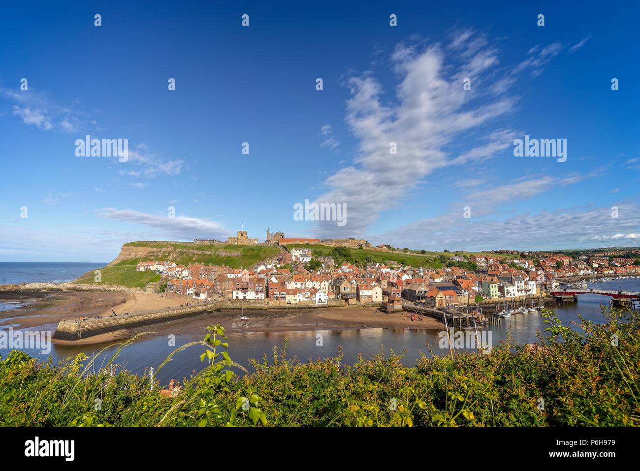 A view of the cliff and harbour at Whitby, There is a church on top of ...