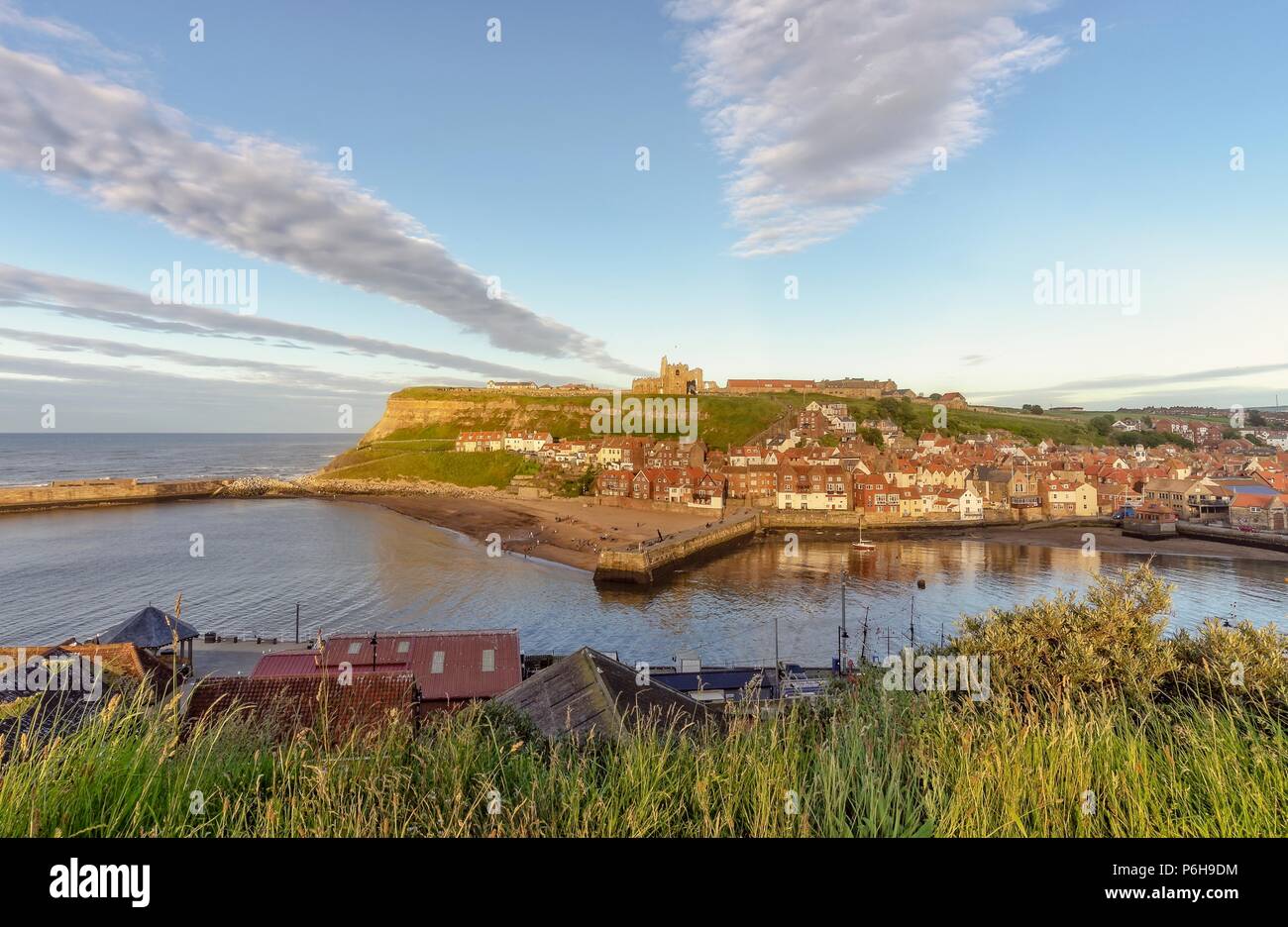 A view of the cliff and harbour at Whitby, There is a church on top of ...