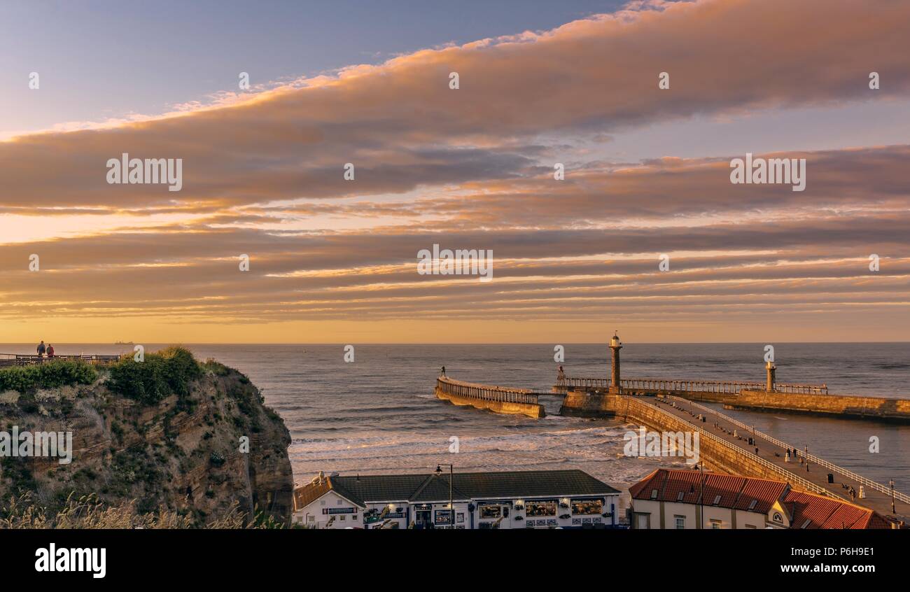 Sunset in Whitby looking out to sea from the cliff and the quay to the ...