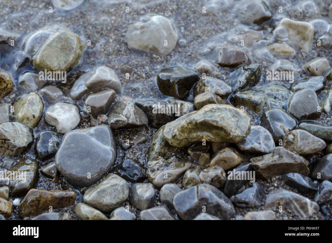 Wet stones in a lake Stock Photo - Alamy