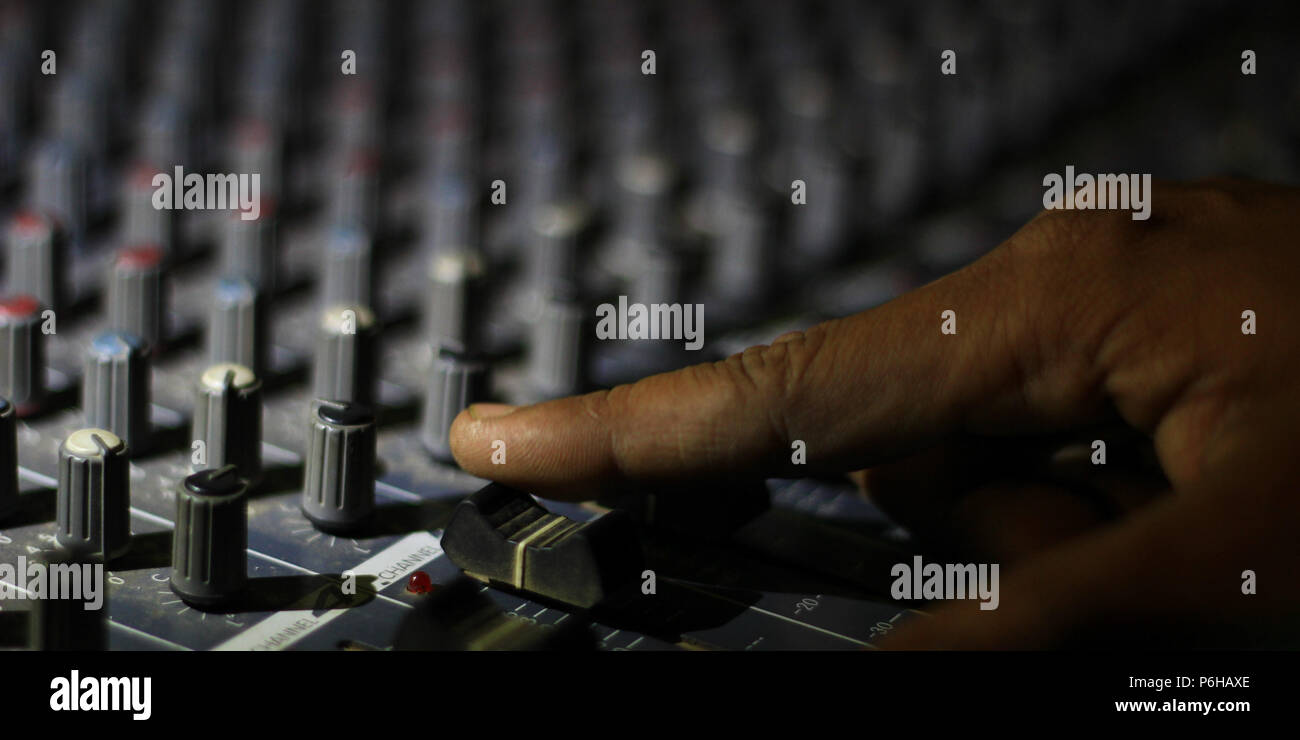hands operating slider of light and sound board console at a concert ...