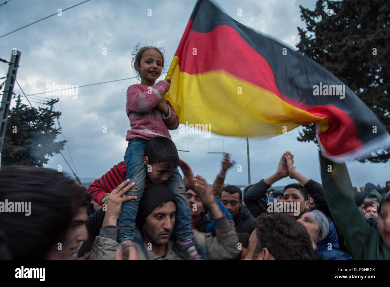 Refugees girl wave a German flag as they call for borders to be open ...