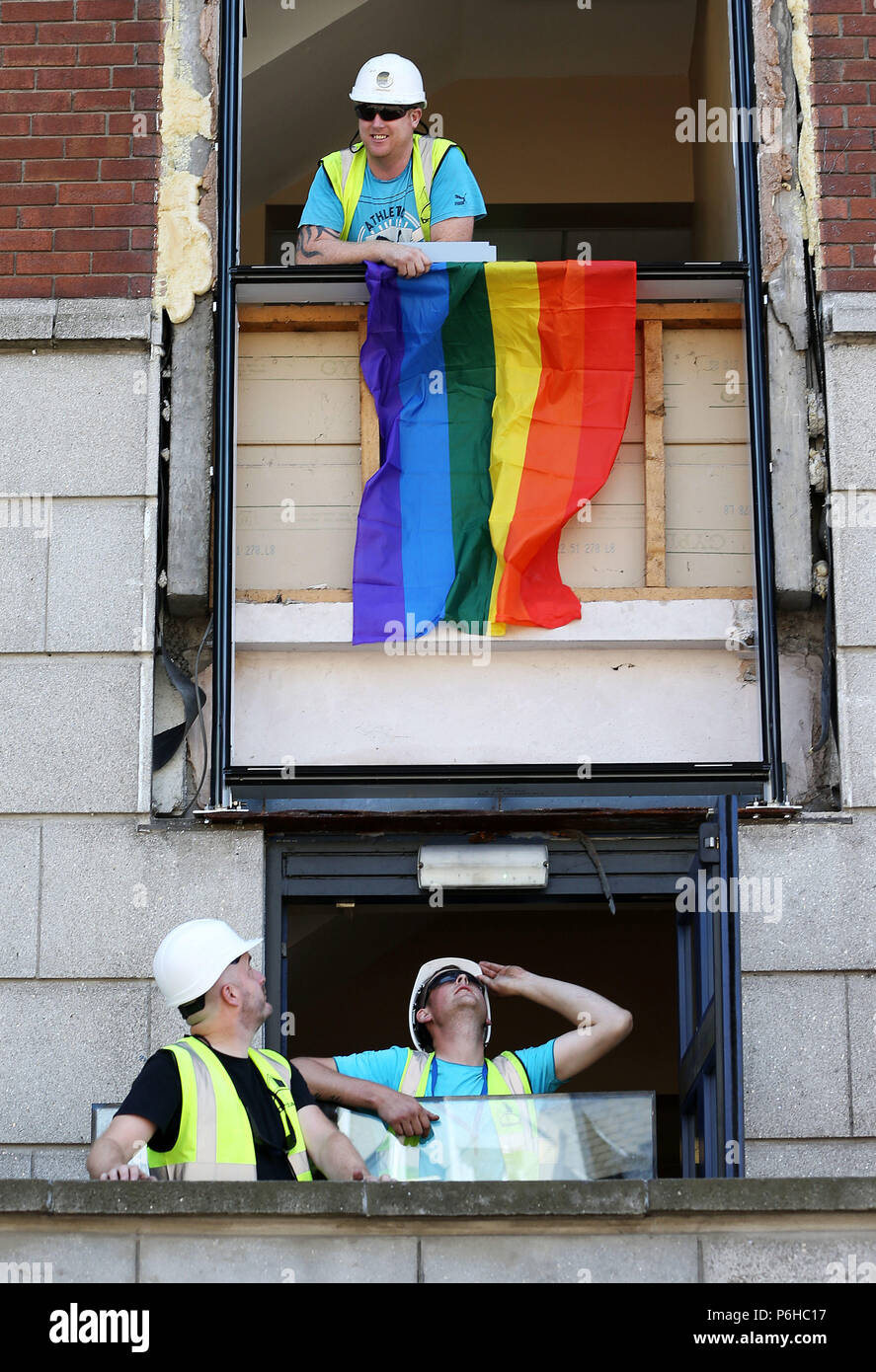 Construction workers take a break to watch the Pride Parade in Dublin ...