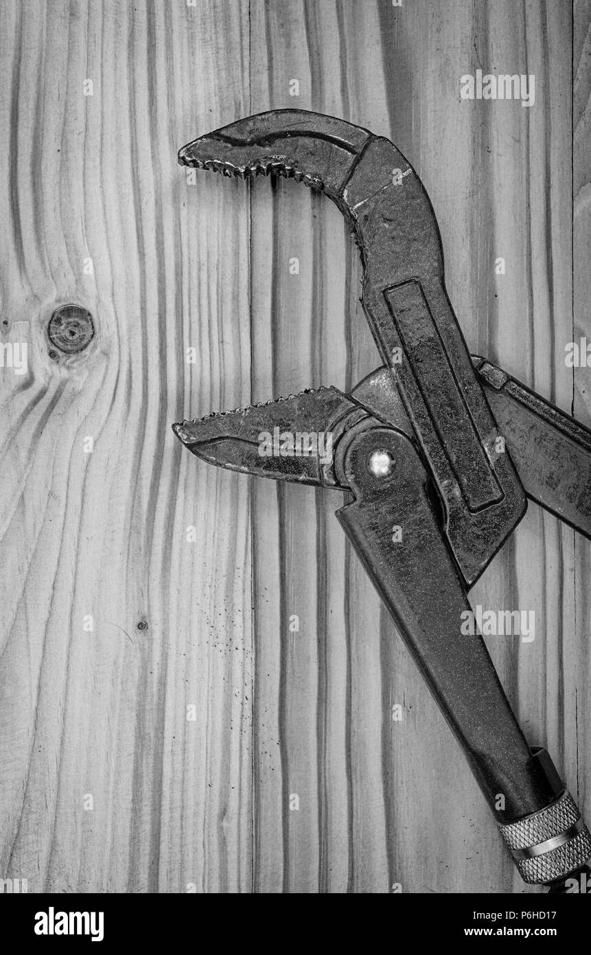 Pipe wrench on a wooden table in black and white Stock Photo - Alamy