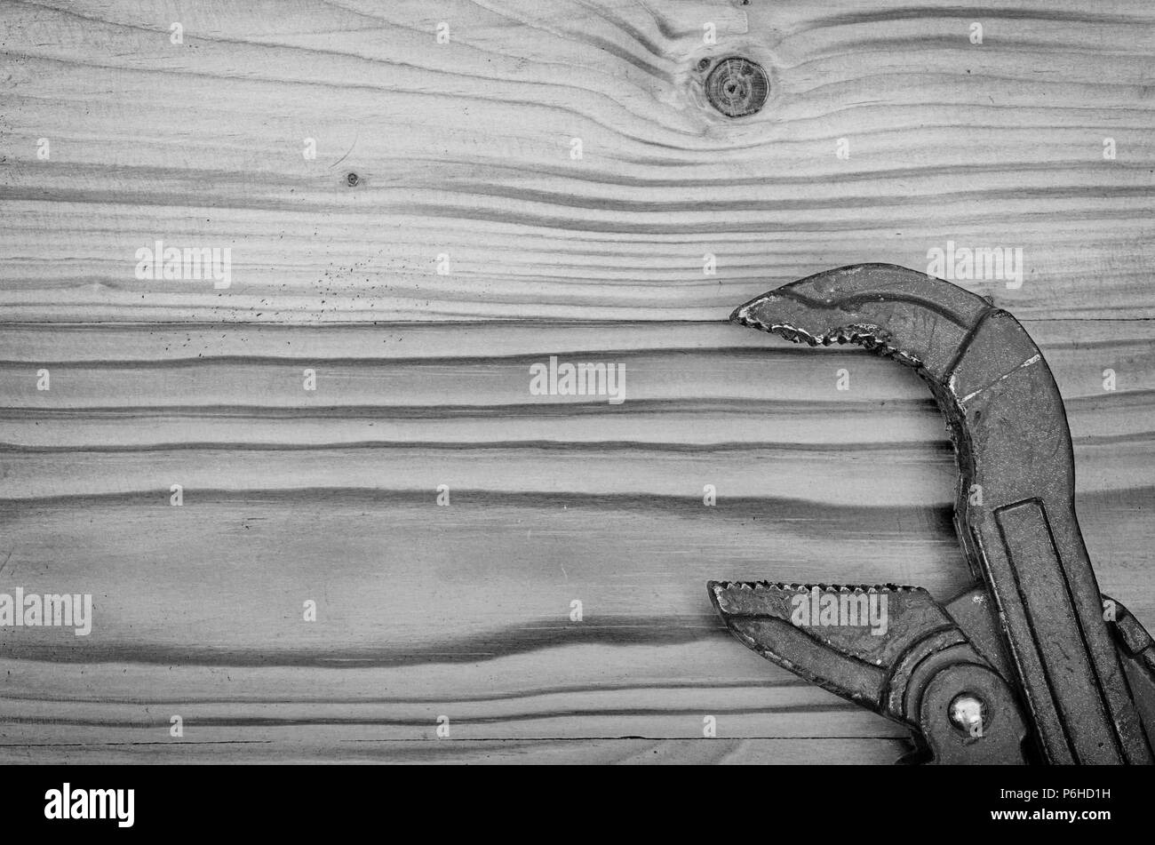 Pipe wrench on a wooden table in black and white Stock Photo - Alamy