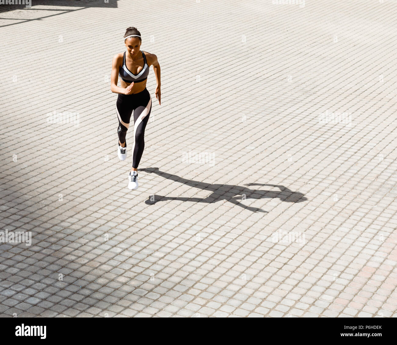 Young muscular woman running on city street, high angle view Stock ...