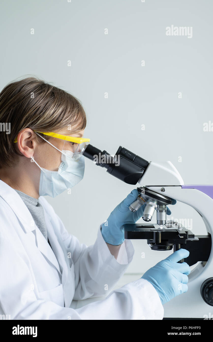 Scientist looking through a microscope Stock Photo - Alamy
