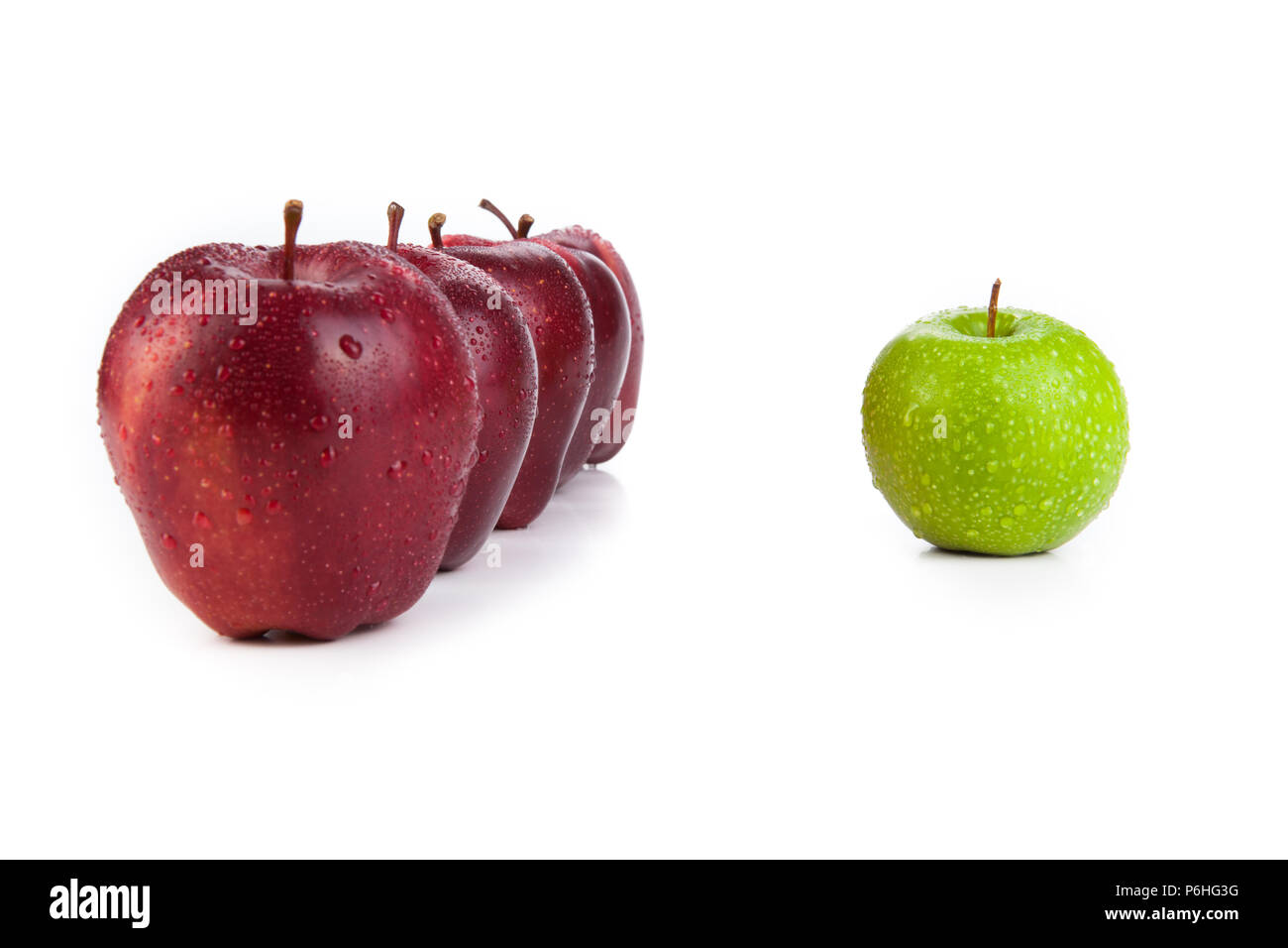 maroon apples lined up in a row and green apple closeup on a white ...