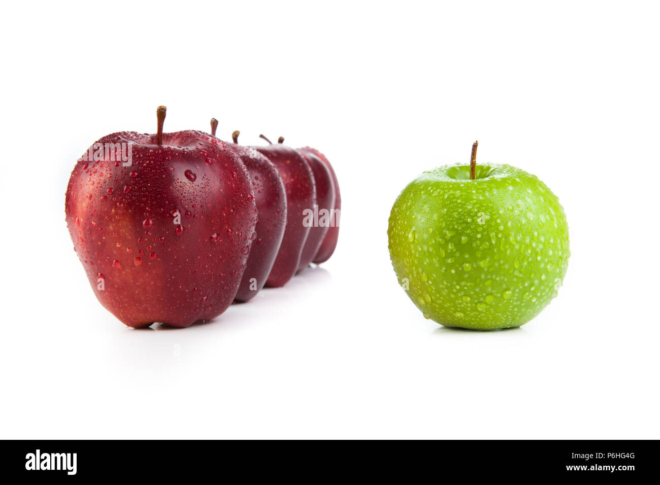 maroon apples lined up in a row and green apple closeup on a white ...