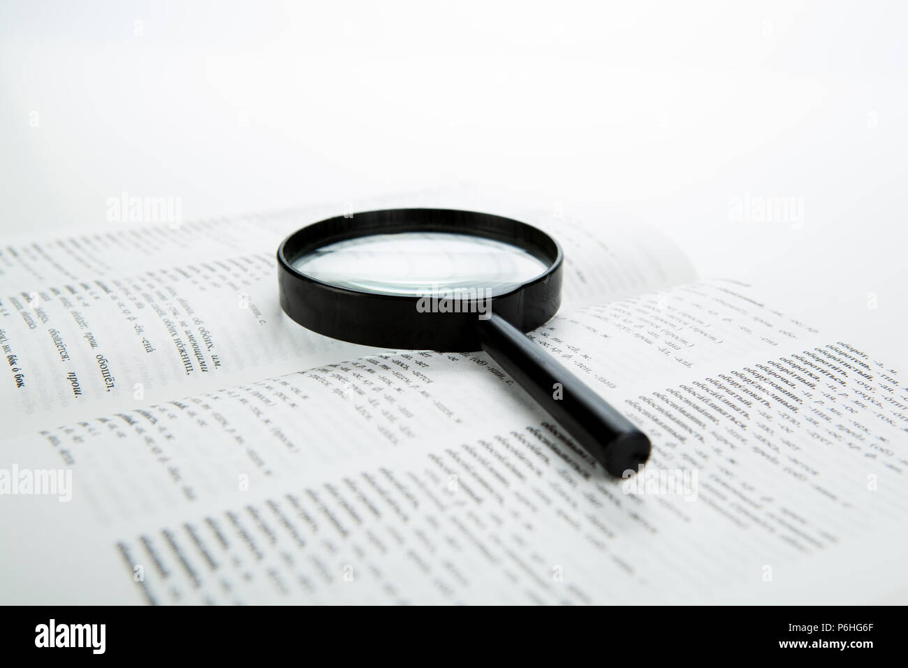 open book with loupe closeup on a white background Stock Photo - Alamy