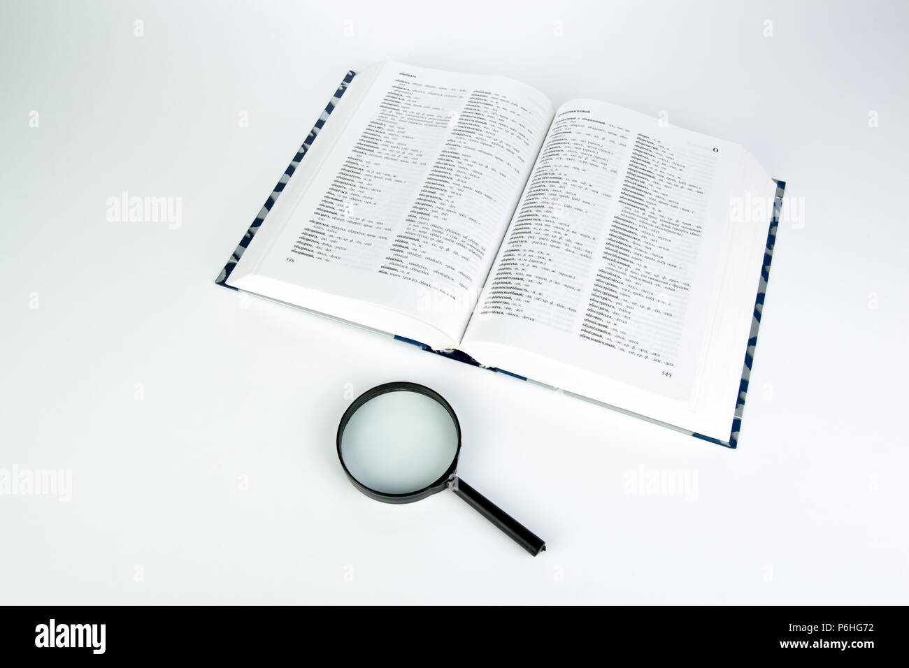 open book with loupe closeup on a white background Stock Photo - Alamy