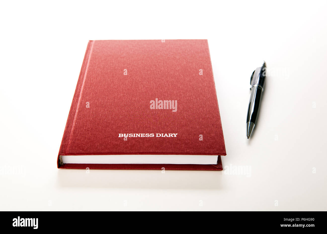 open diary with large pen on white Stock Photo - Alamy
