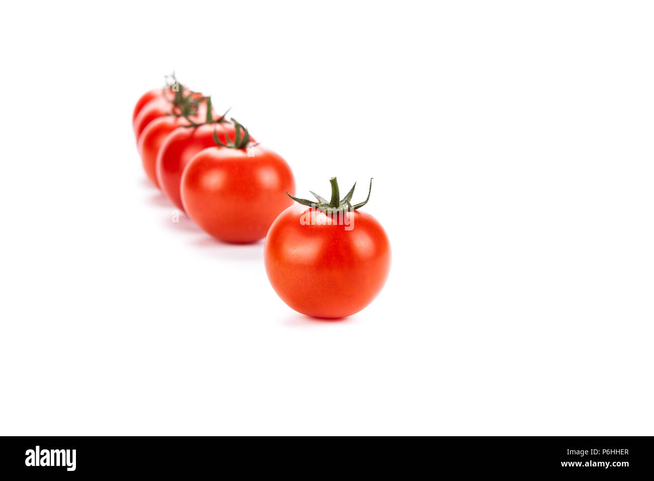 six red tomatoes lined up in a row on a white background Stock Photo ...