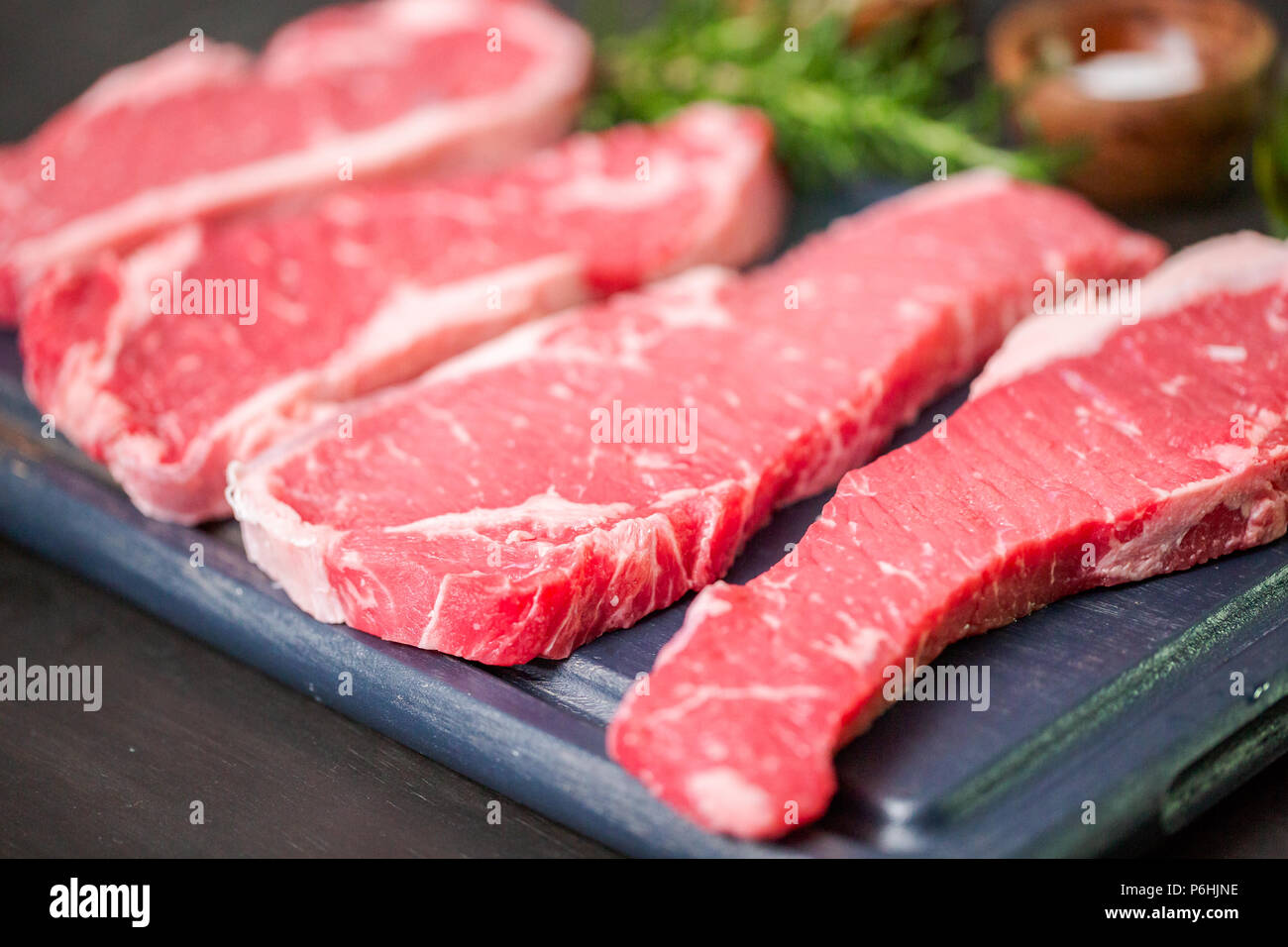 Raw New York strip steaks on a wood cutting board Stock Photo - Alamy