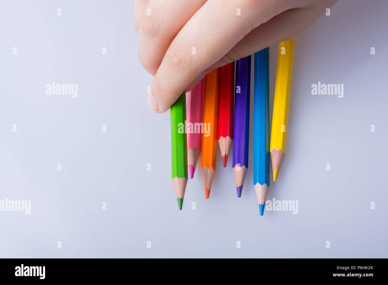 Hand holding color Pencils placed on a white background Stock Photo - Alamy