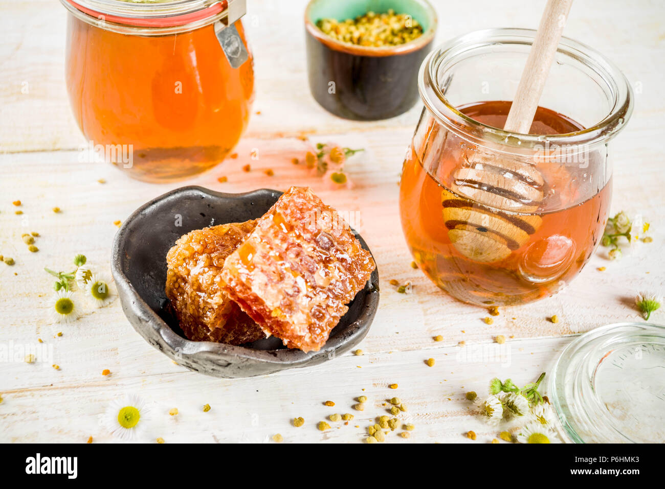 Organic floral honey, in jars, with pollen and honey combs, on a white ...
