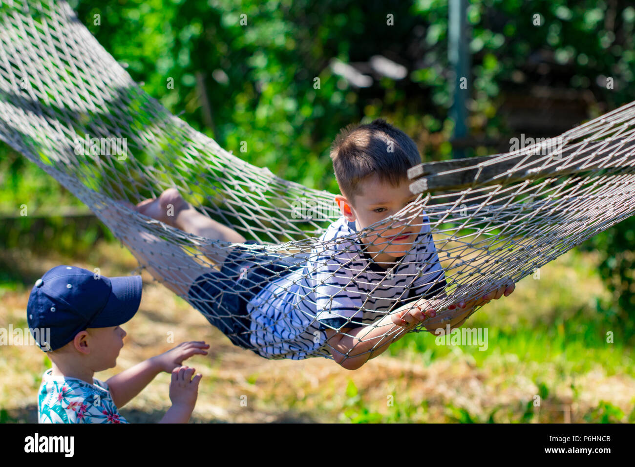 Two boys in a hammock in the garden Stock Photo - Alamy