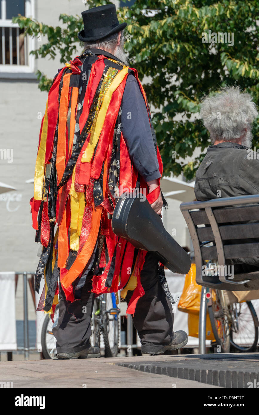 traditional English morris dancing mummer walks down street carrying a ...