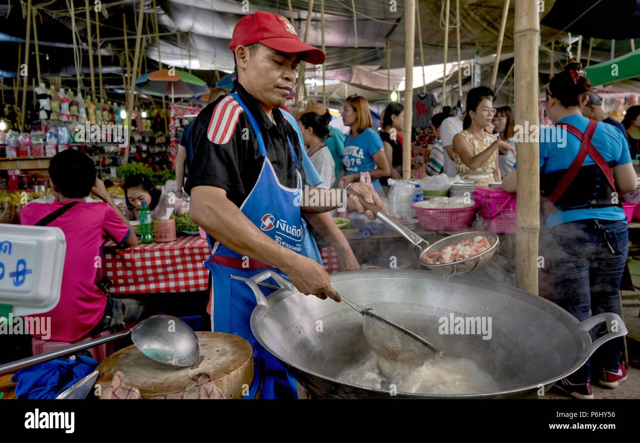 Man cooking in a Thailand indoor food market. Southeast Asia Stock ...
