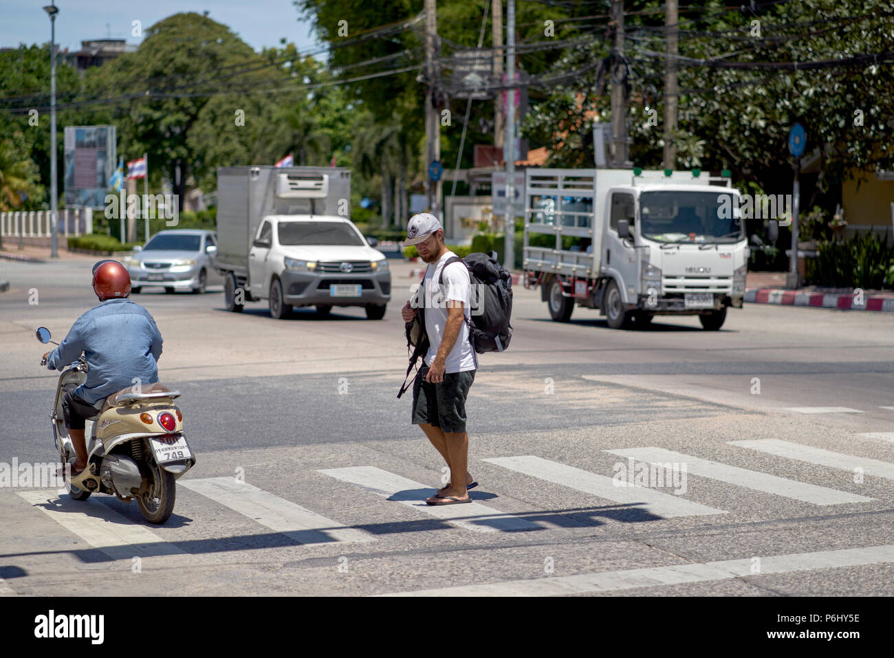 Man crossing road using the pedestrian crossing with motorcyclist ignoring his right of way. A ...