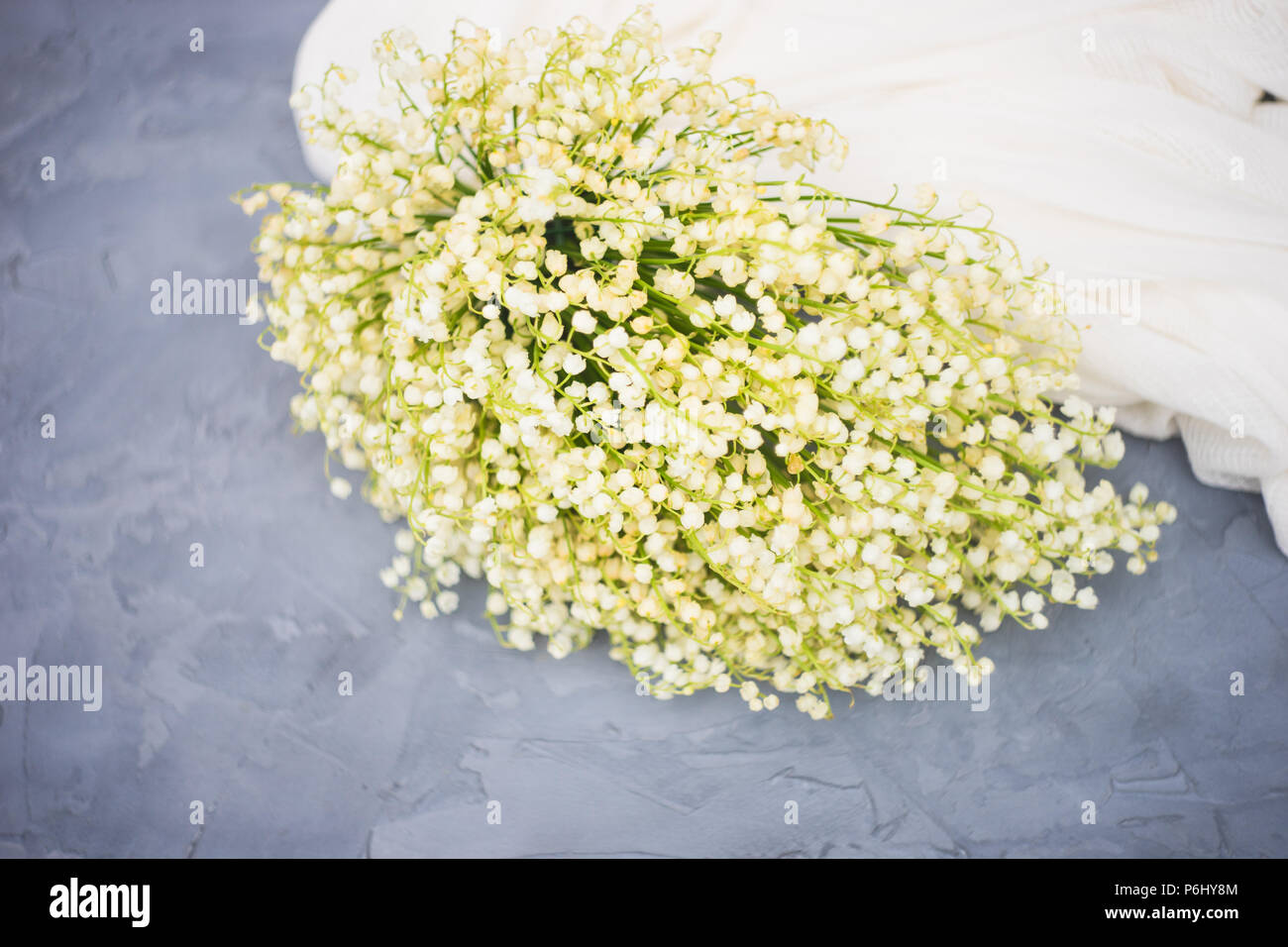 Beautiful may lilies in bride bunch on rustic background with copy ...