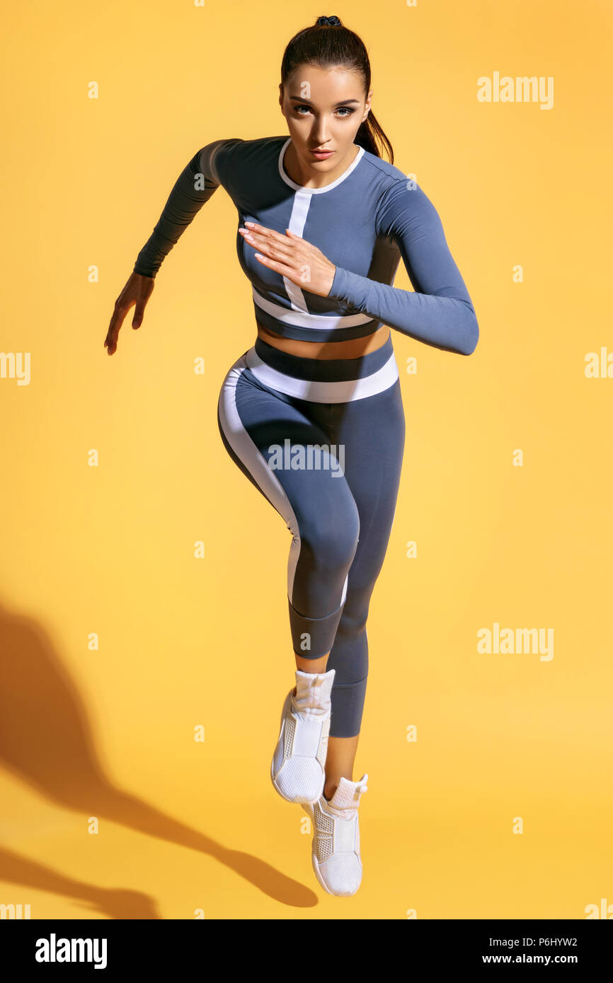 Beautiful woman runner in silhouette on yellow background. Photo of ...