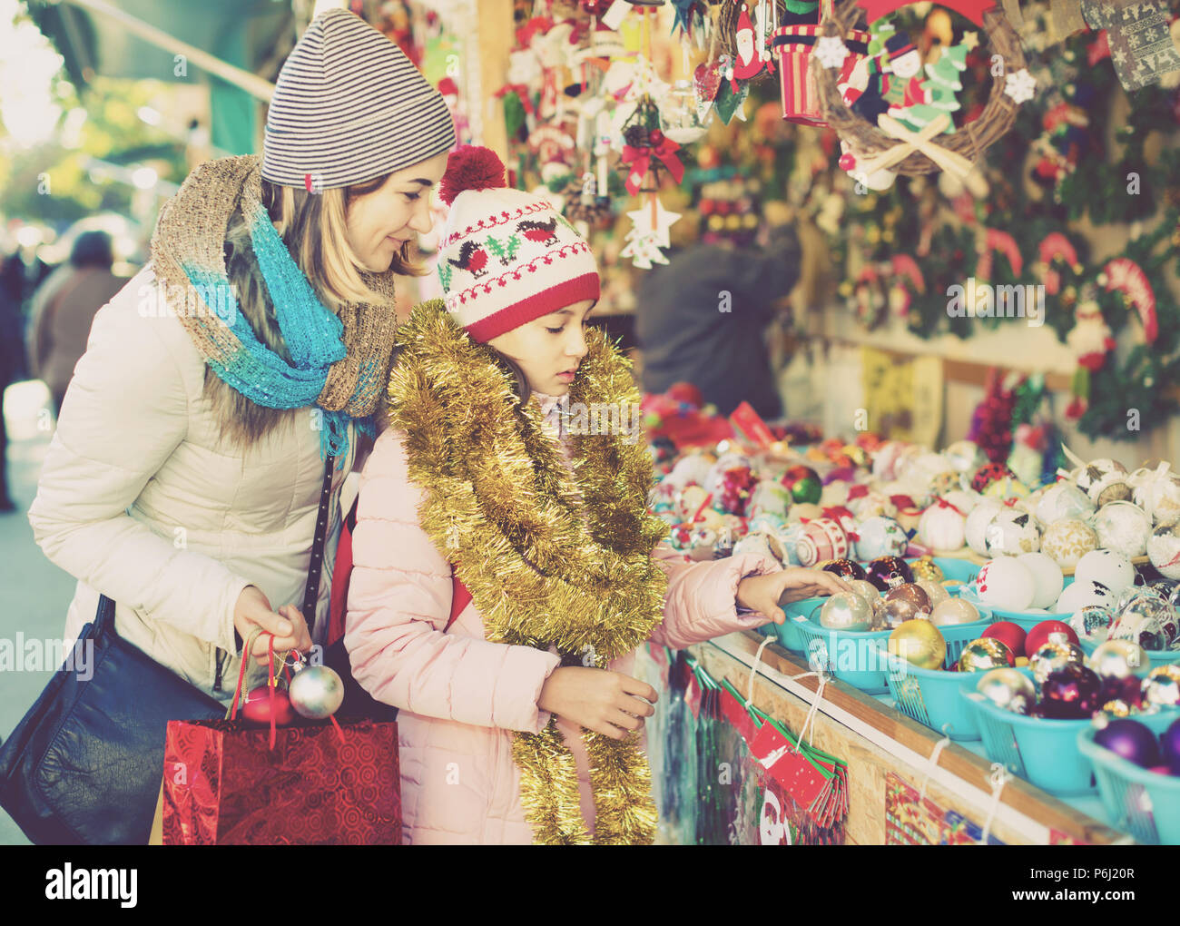 Happy smiling female customers staring at counter of Christmas market ...