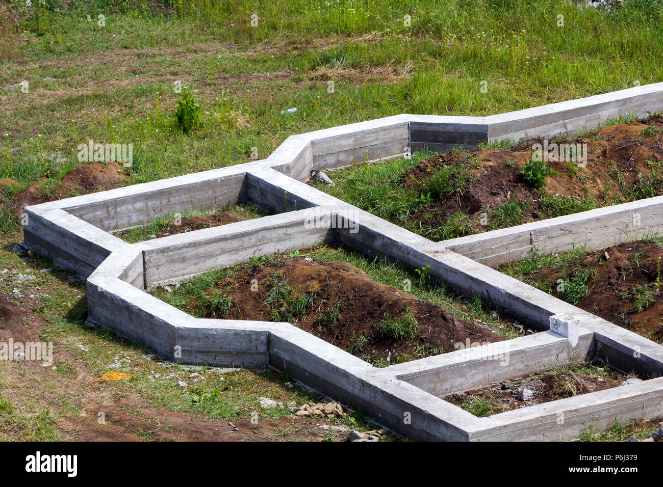 Building site in green field. Close-up detail of trenches dug in ground ...