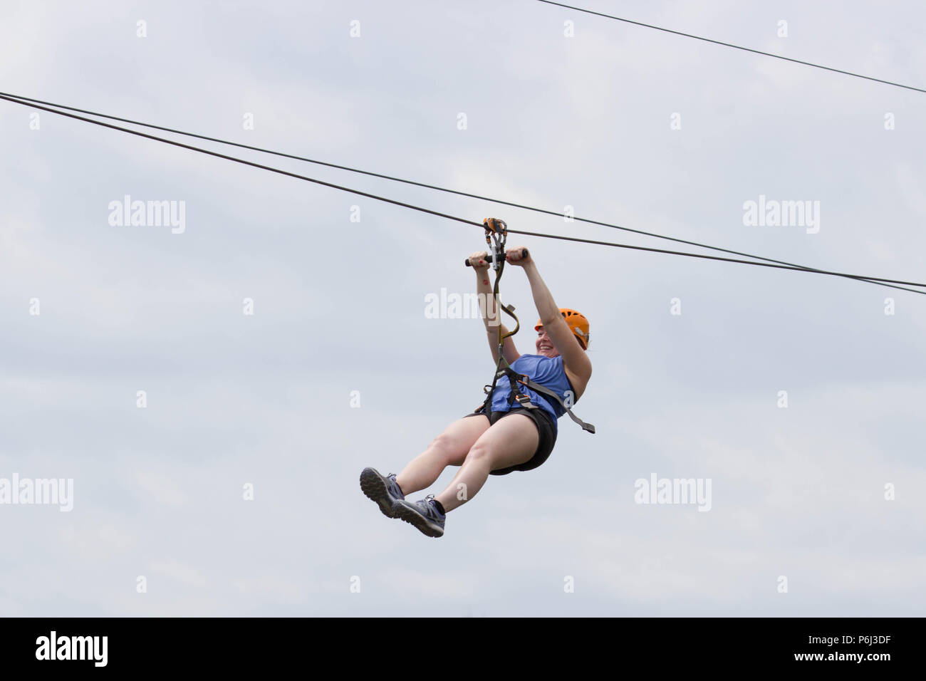 Girl zip-lining with a smile Stock Photo - Alamy
